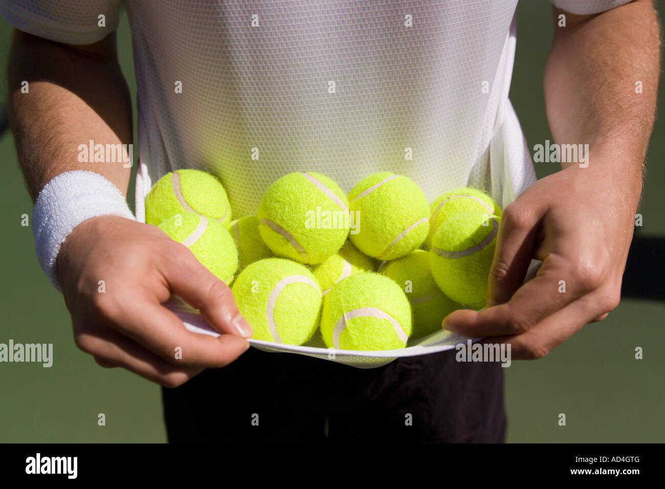 Midsection view of a man carrying tennis balls in his t-shirt Stock ...