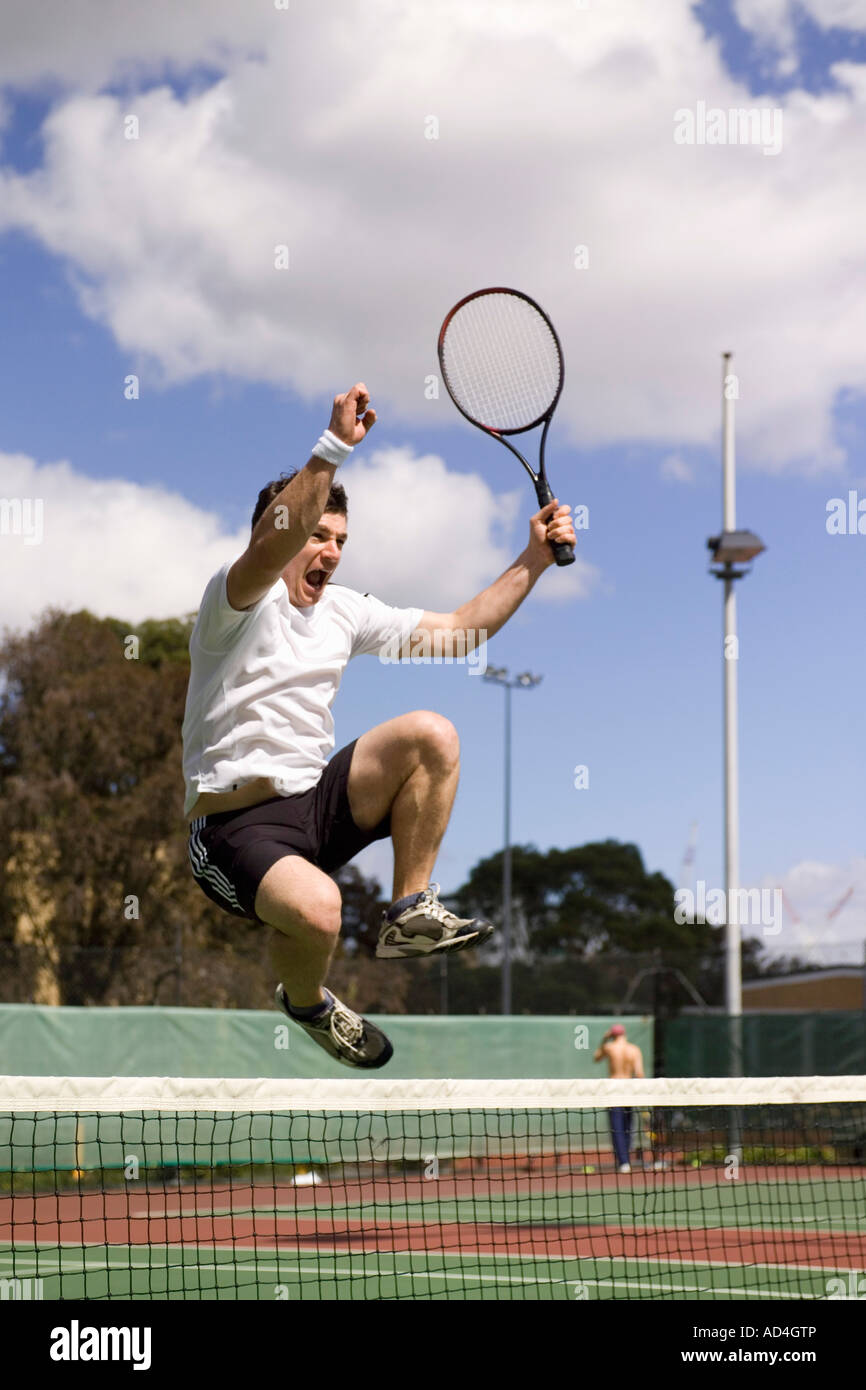 A tennis player leaping over the net Stock Photo - Alamy