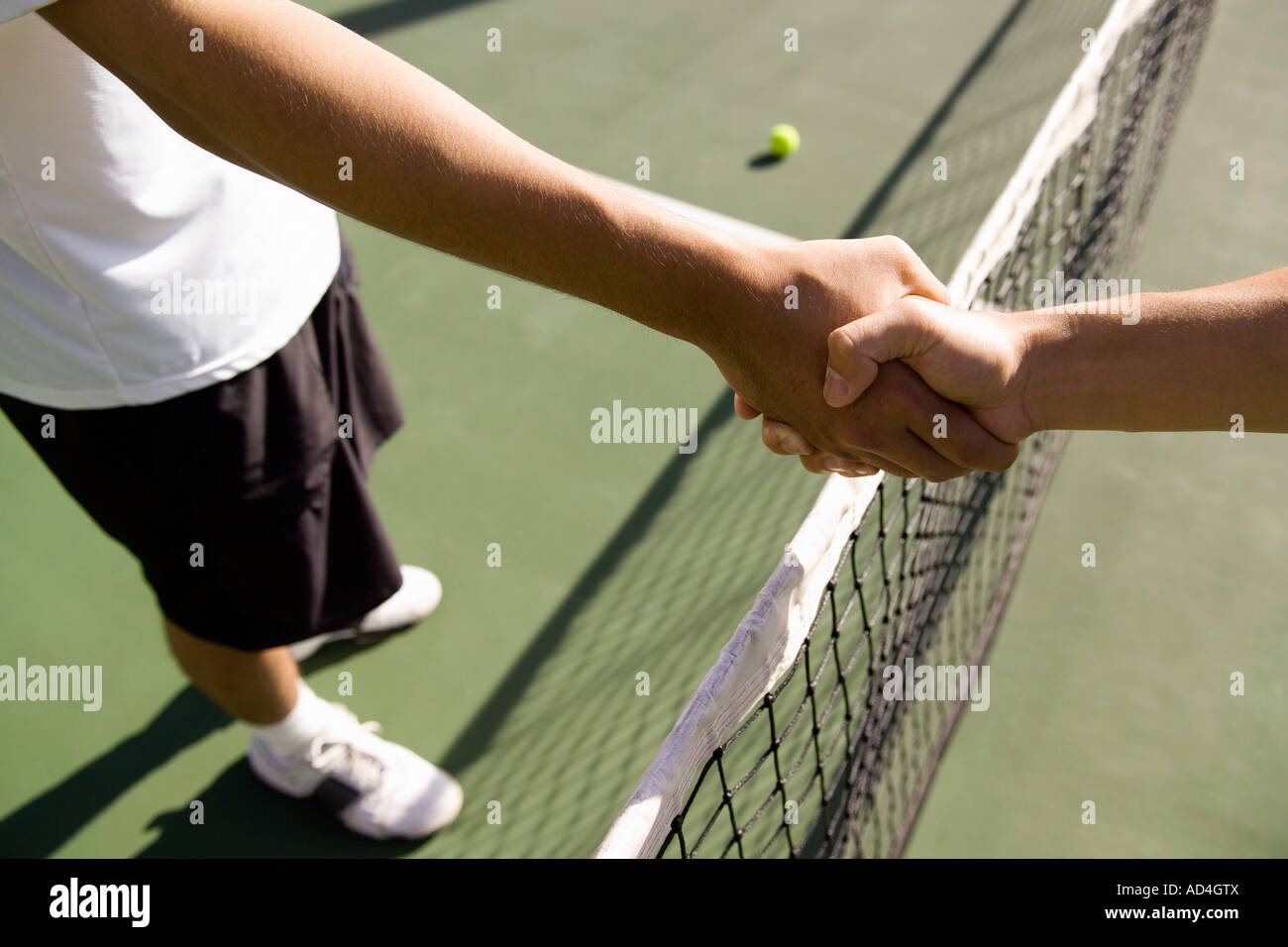 Two tennis players shake hands across the net Stock Photo - Alamy