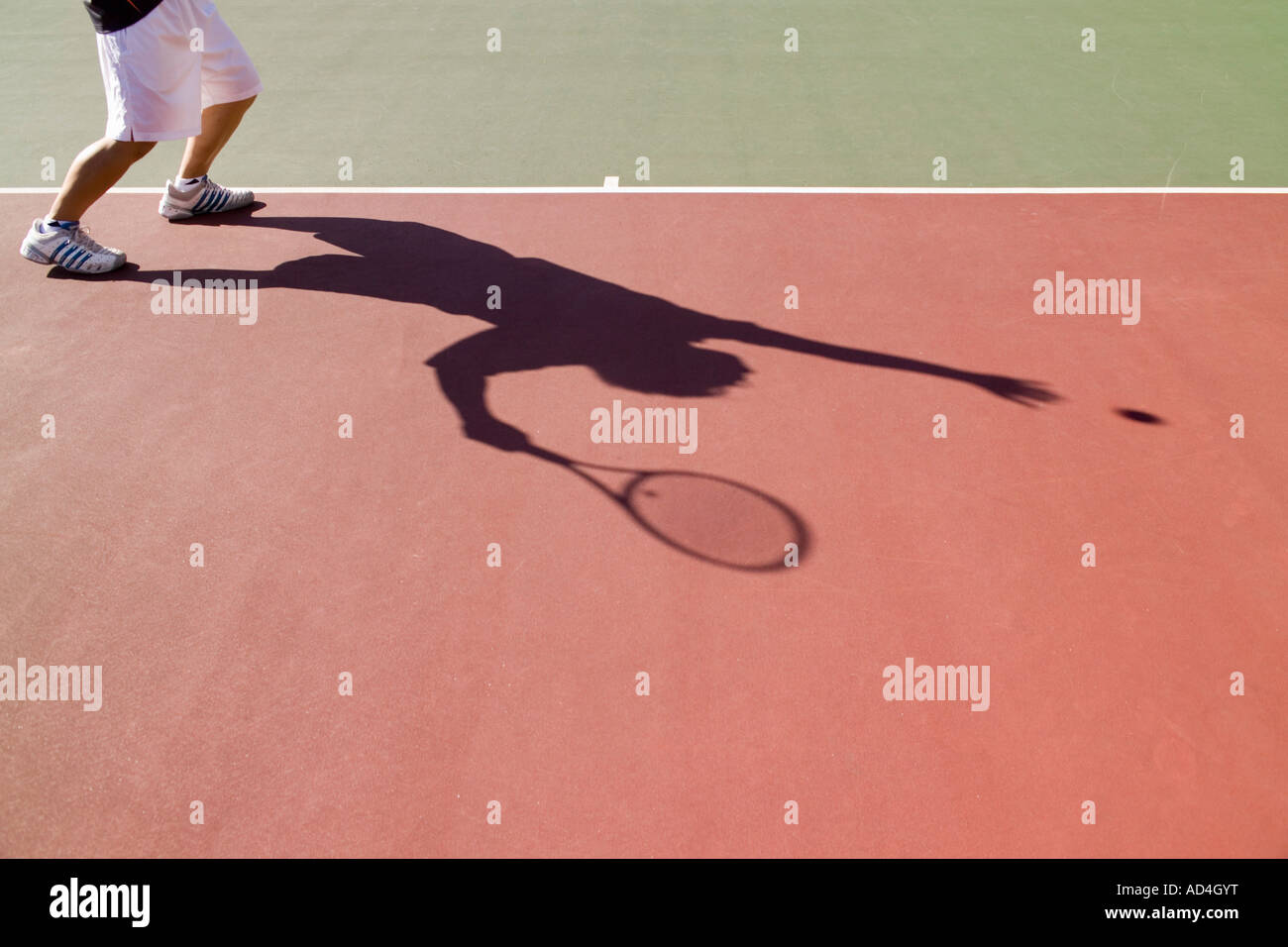 Low section of a tennis player and his shadow Stock Photo - Alamy