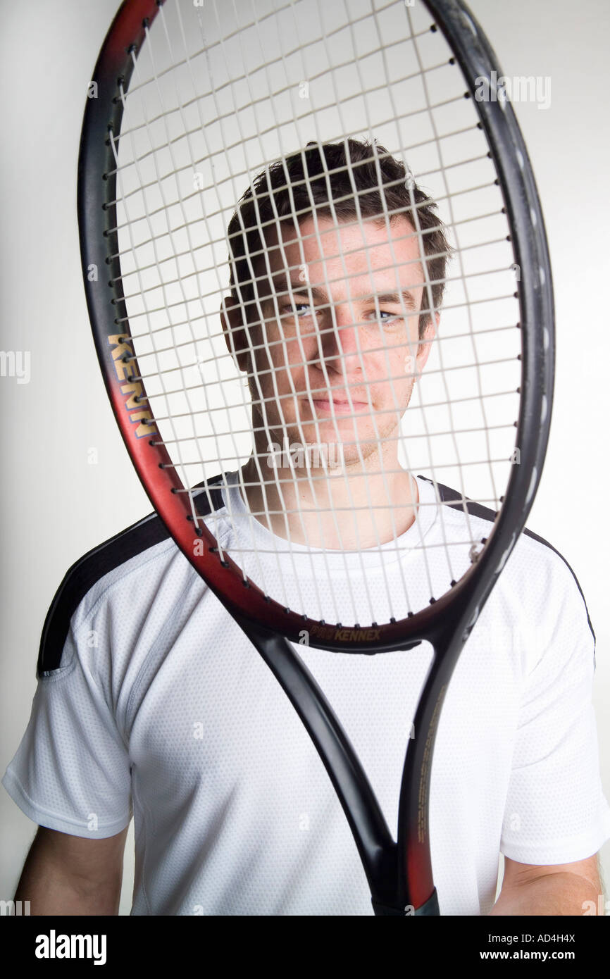 A tennis playing holding his tennis racquet in front of his face Stock ...