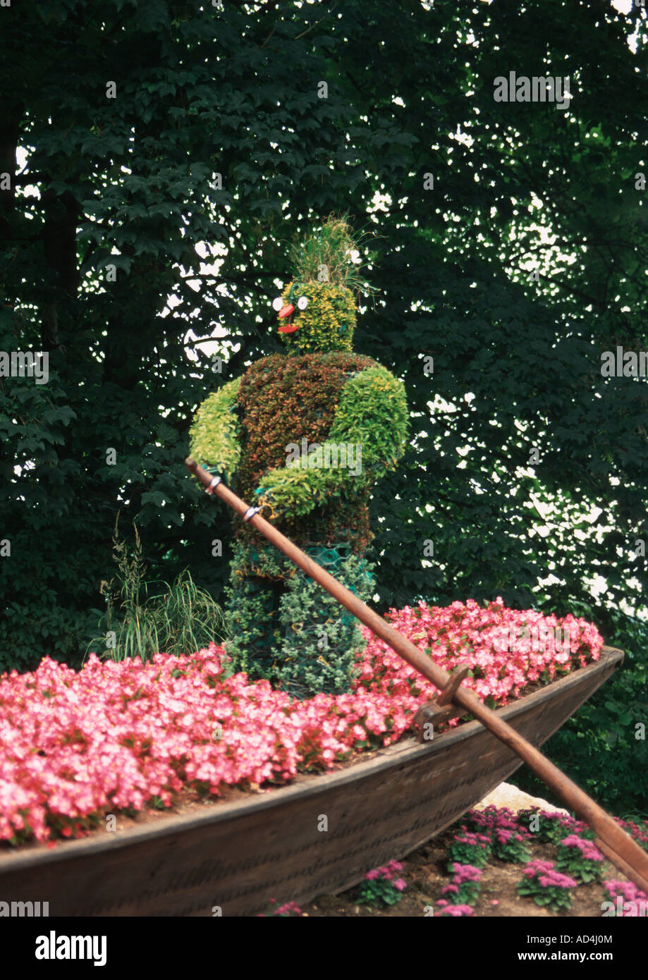 Flower man rowing a boat in an ornamental garden Stock Photo - Alamy