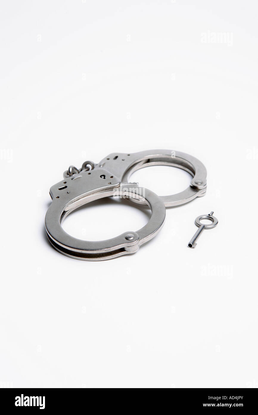 A pair of handcuffs and a key Stock Photo - Alamy