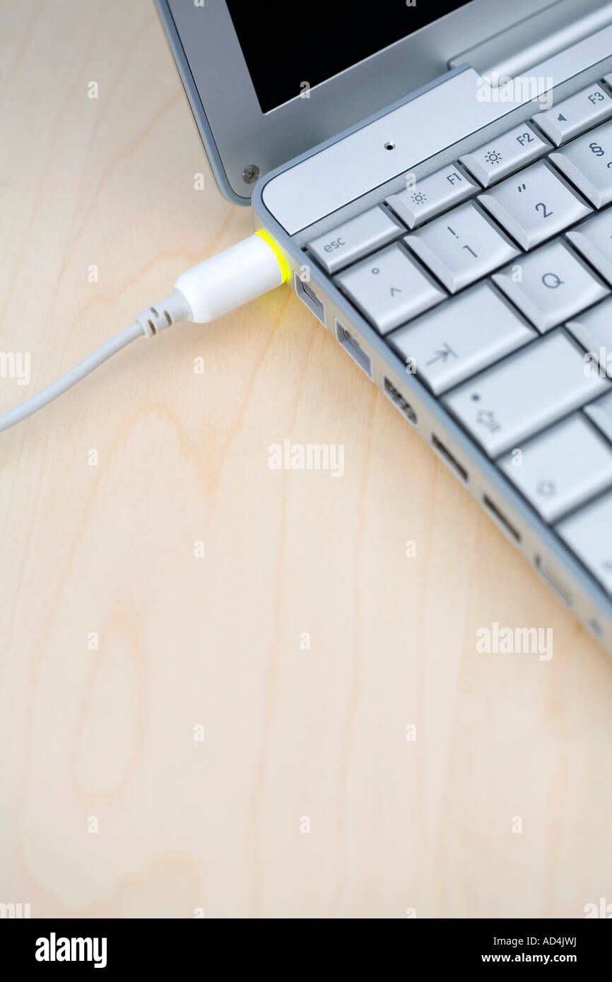 A power cable connected to a laptop Stock Photo - Alamy