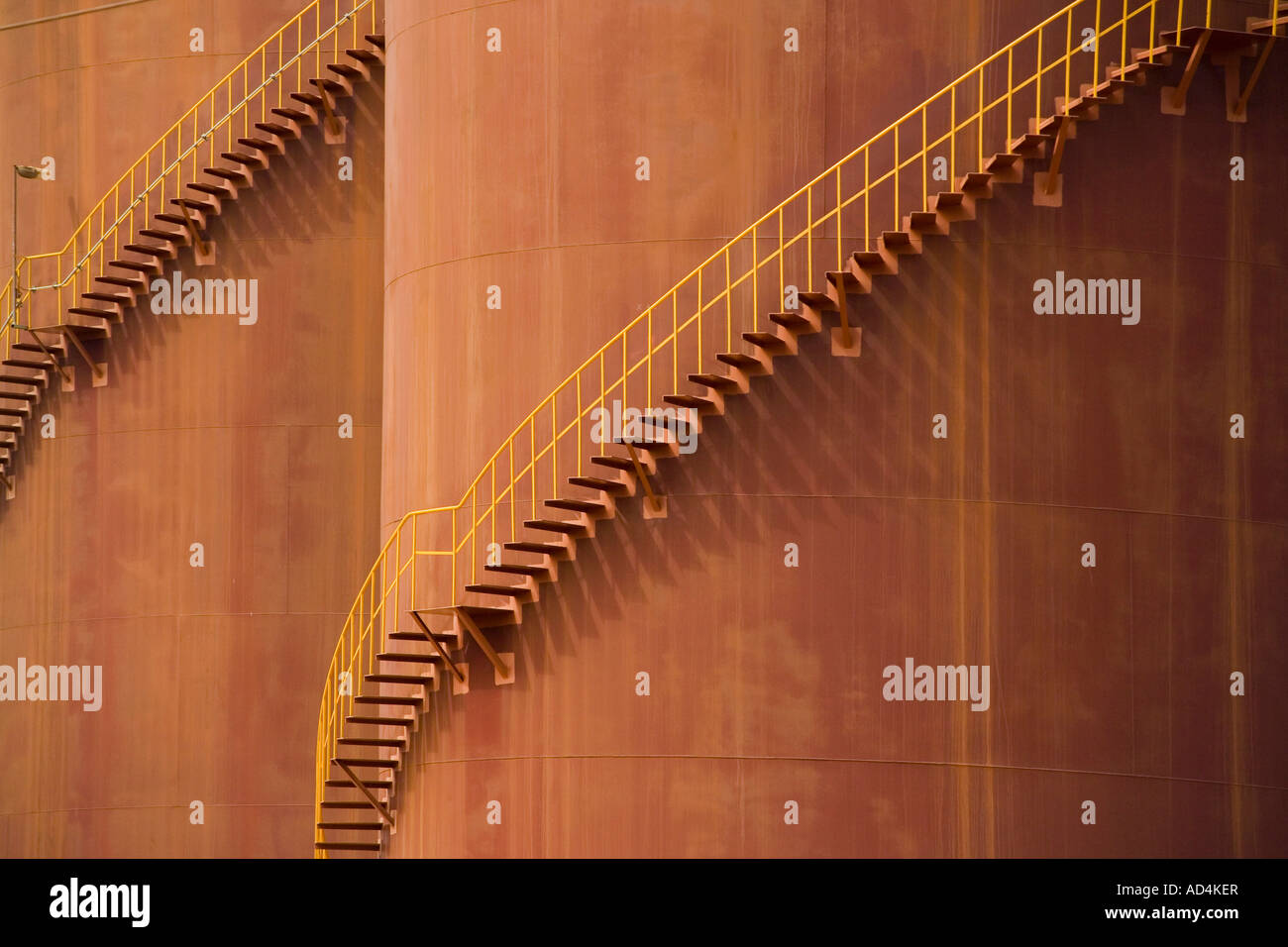 Detail of stairs curving around large storage tanks Stock Photo - Alamy
