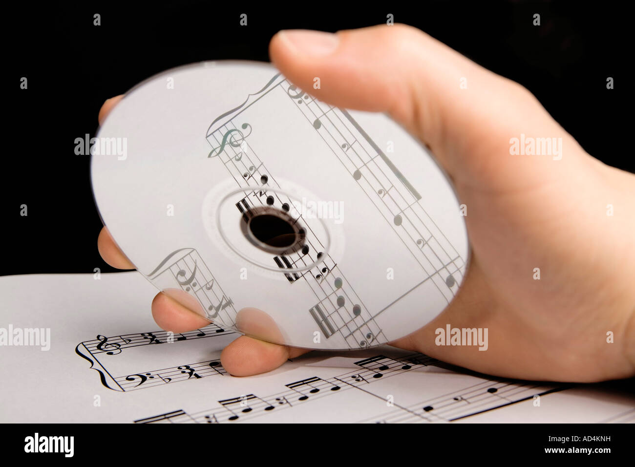 A man holding an audio CD above sheet music Stock Photo - Alamy