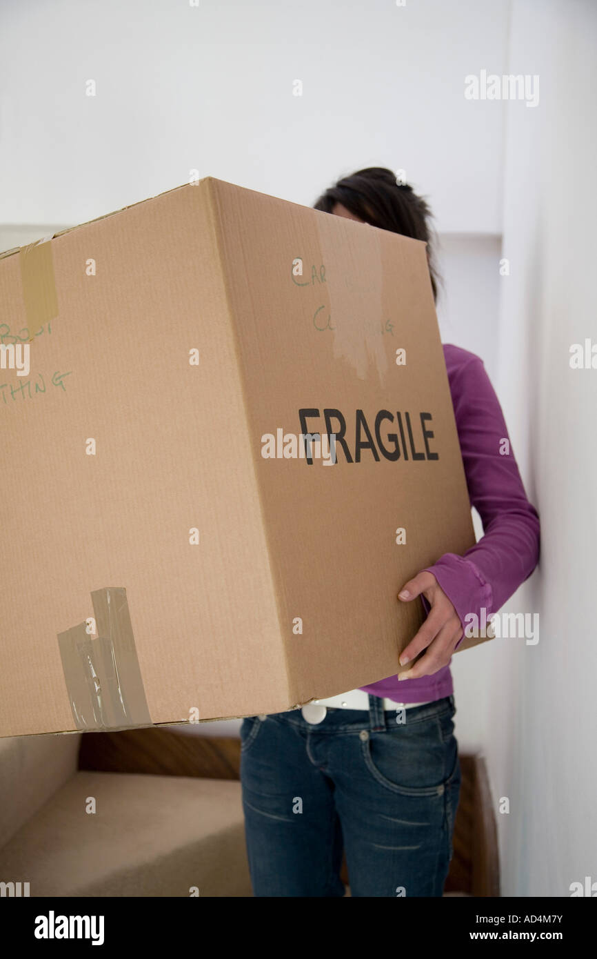 A woman carrying a cardboard box Stock Photo - Alamy