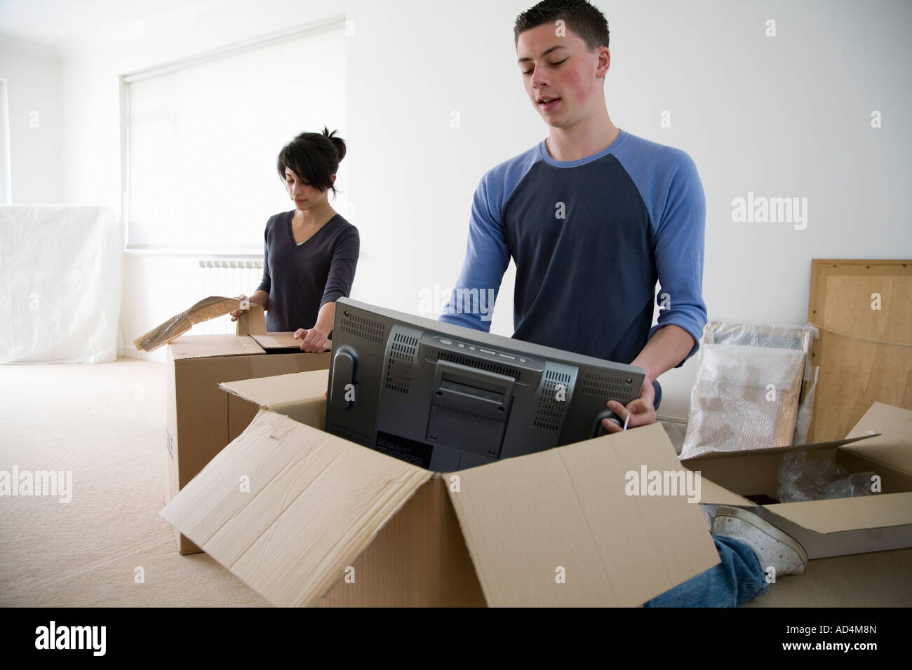 Two teenagers unpacking boxes Stock Photo - Alamy