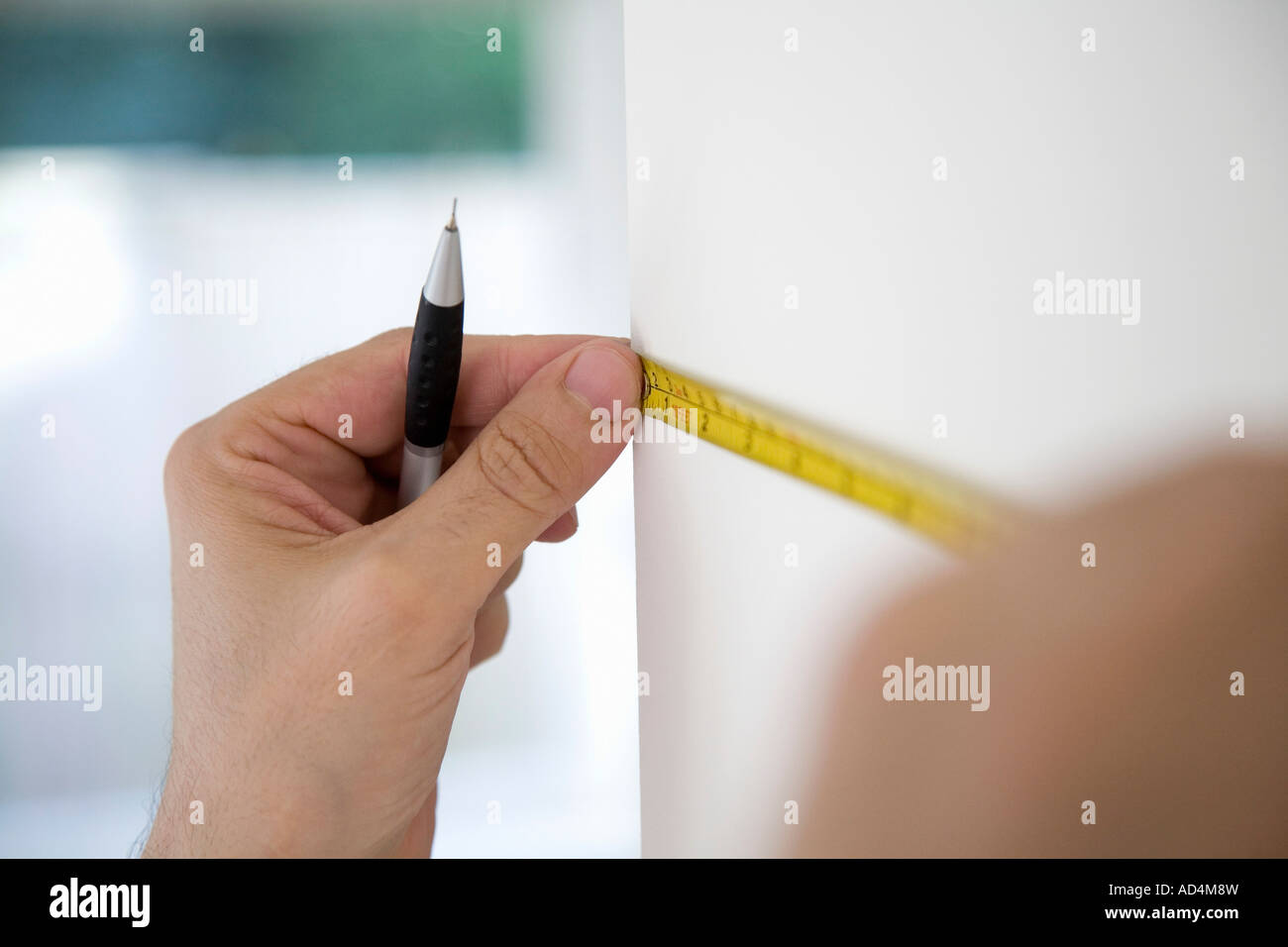 Close up of hands measuring a wall Stock Photo - Alamy