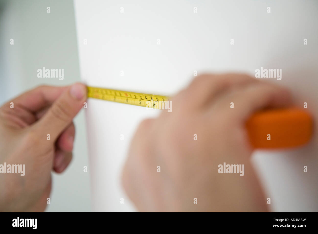 Close up of hands measuring a wall Stock Photo - Alamy