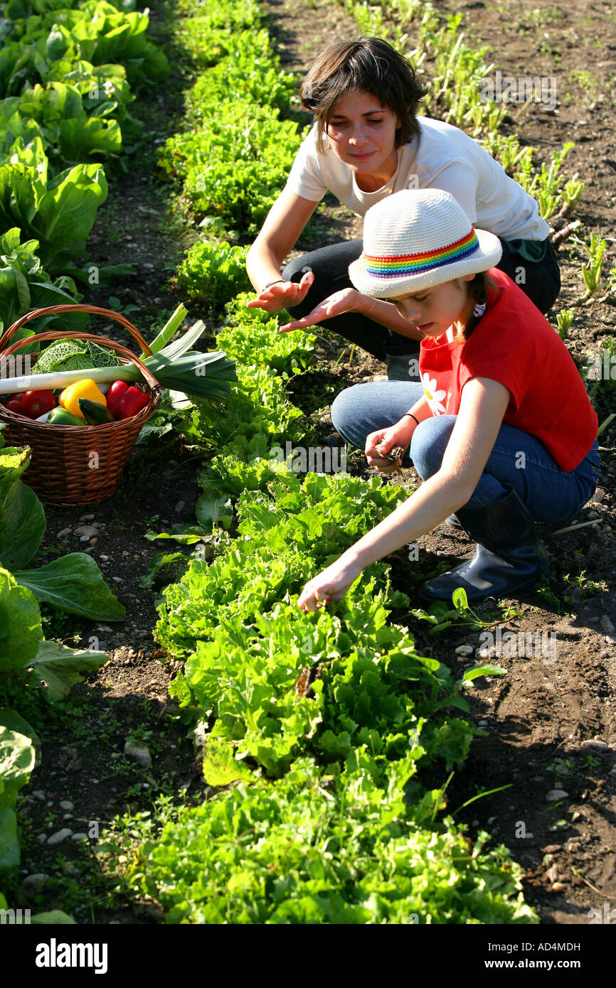 Woman and girl working on a field Stock Photo - Alamy