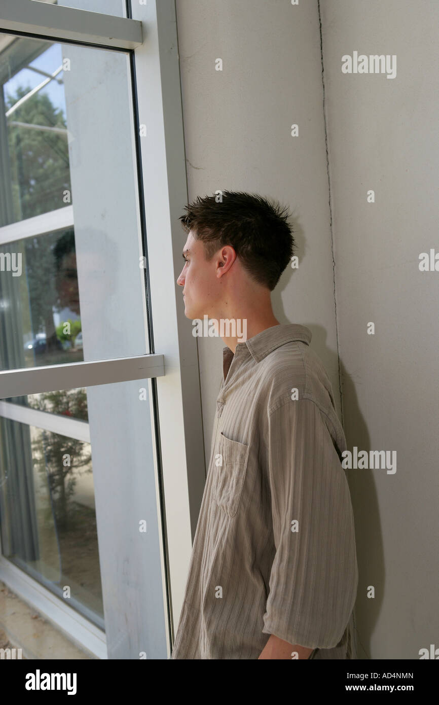 Young man looking out the window Stock Photo - Alamy