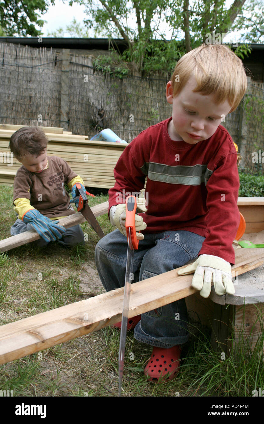 Two young boys sawing wood in a back yard Stock Photo - Alamy