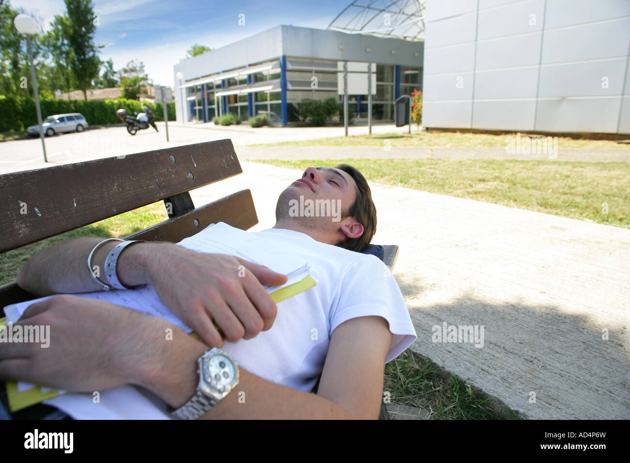 Young man laying on a bench Stock Photo - Alamy