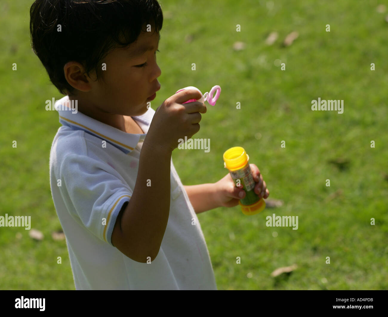 Side profile of a boy blowing bubbles with a bubble wand Stock Photo - Alamy