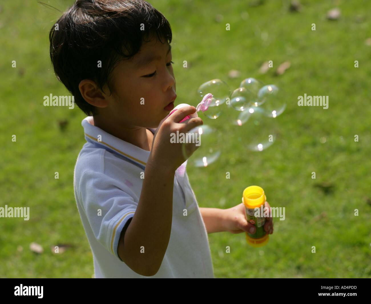 Side profile of a boy blowing bubbles with a bubble wand Stock Photo ...