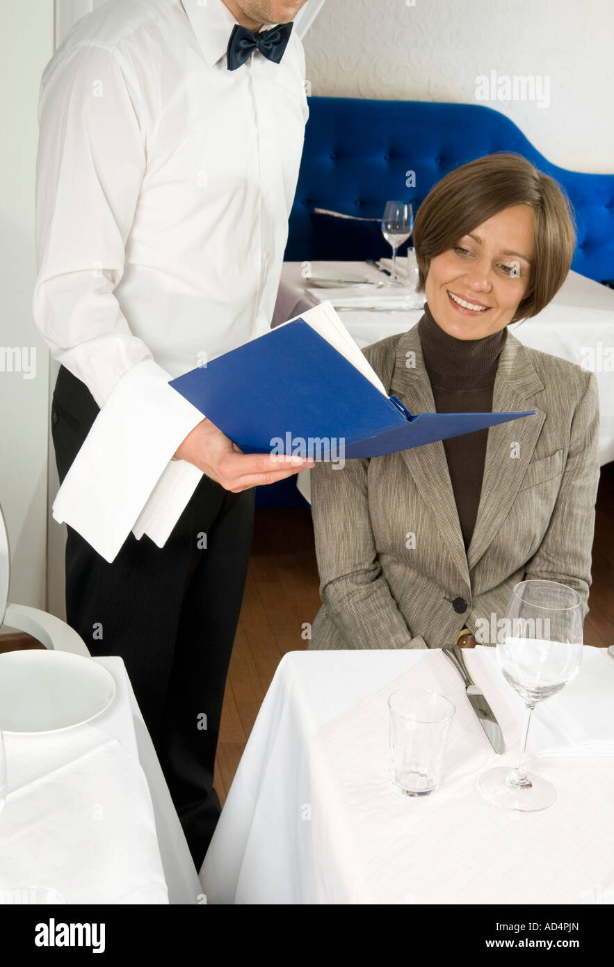 A waiter showing the menu to a woman Stock Photo - Alamy