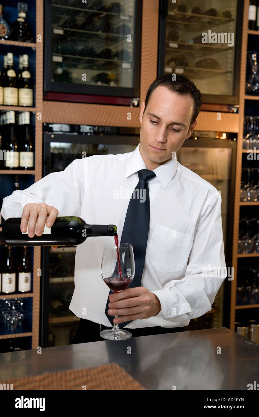 A barman pouring a glass of red wine Stock Photo - Alamy