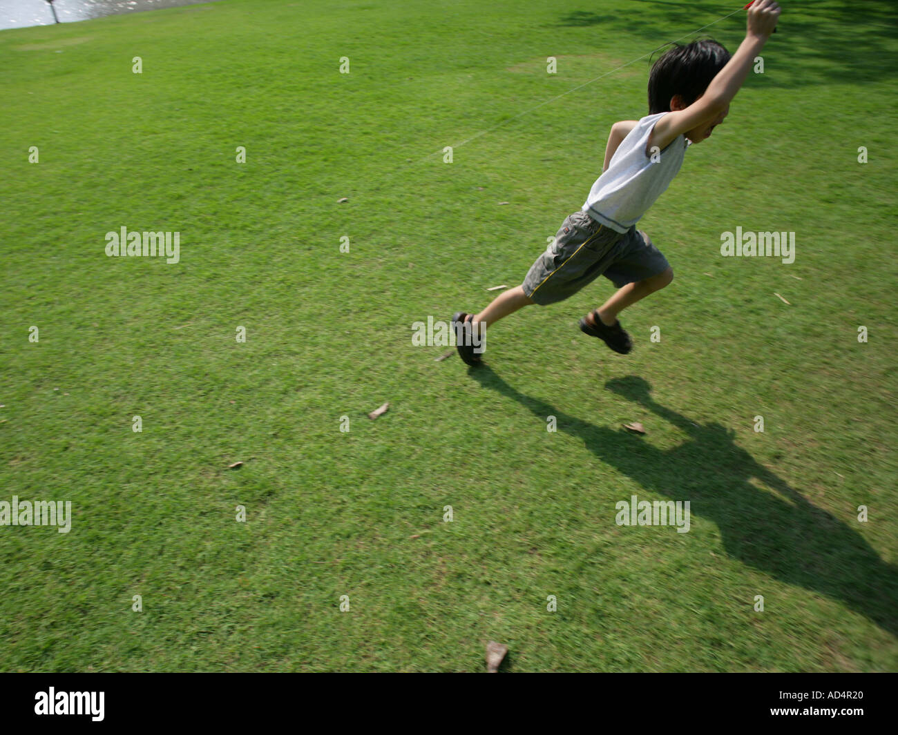 Side profile of a boy running in a park Stock Photo - Alamy