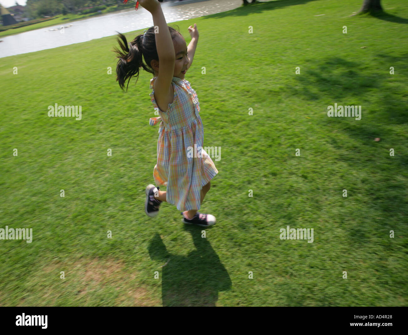 Side profile of a girl running in a park with her arms raised Stock ...