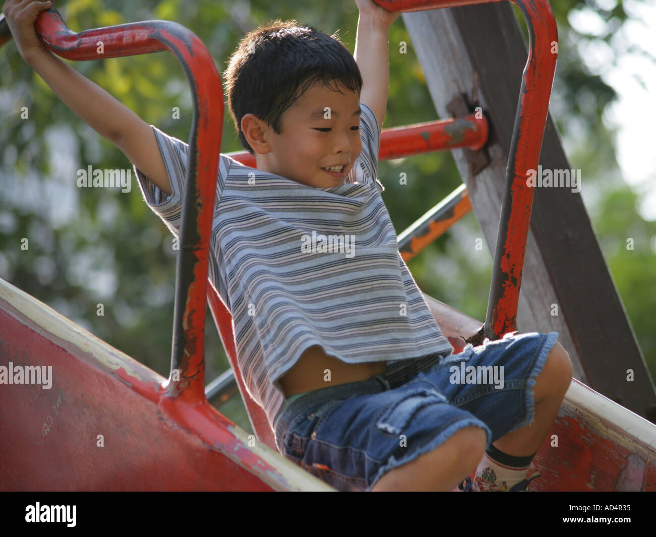 Boy sliding down a slide Stock Photo - Alamy