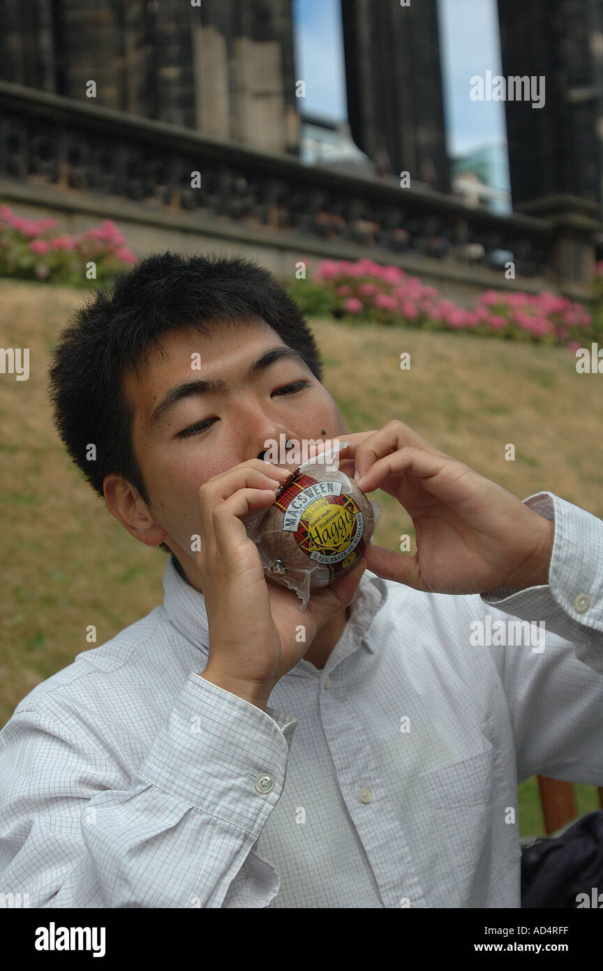 A Japanese visitor to Edinburgh in Princes Street Gardens in front of ...