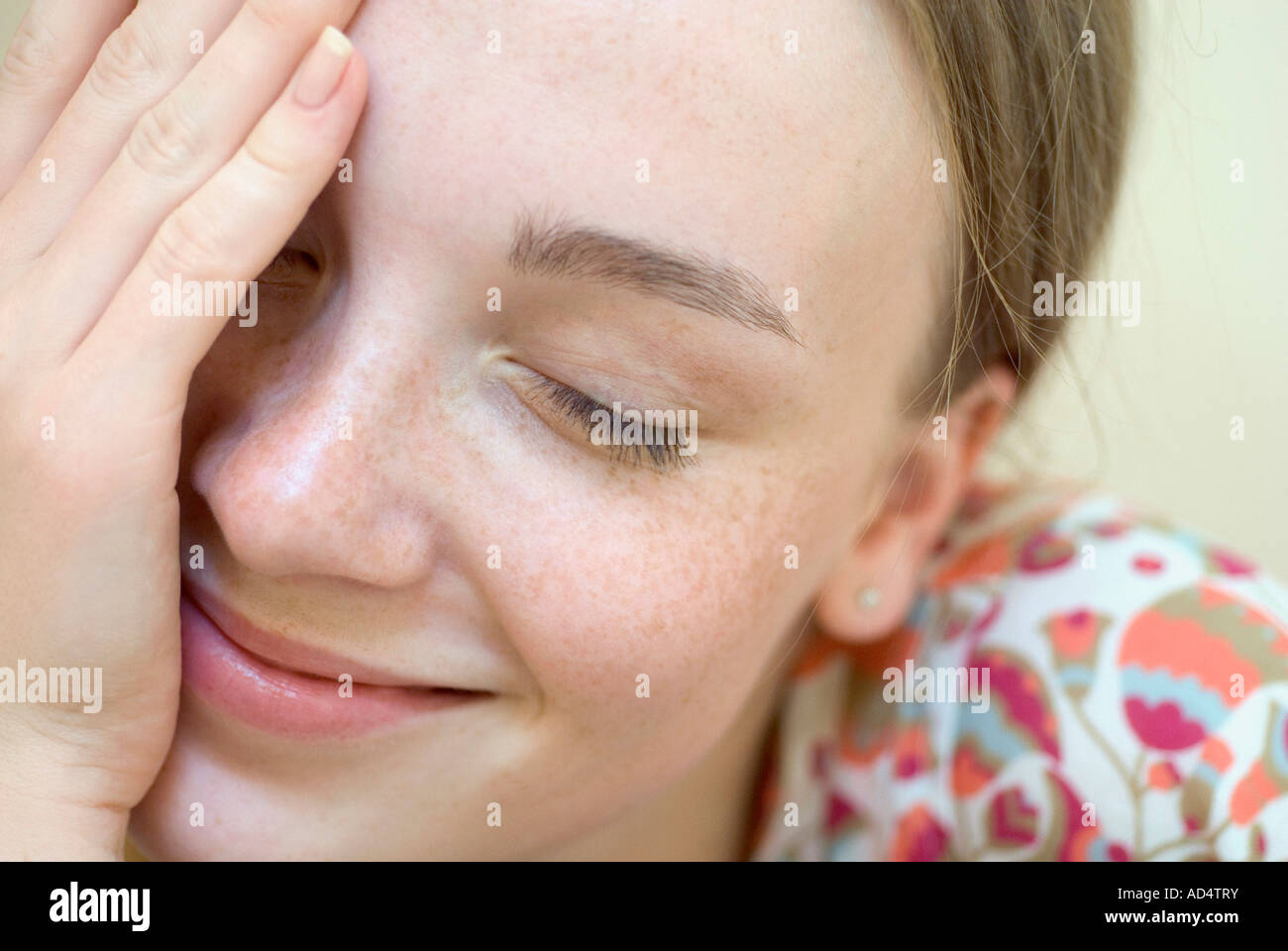 A young woman with her eyes closed and hand over her face Stock Photo ...