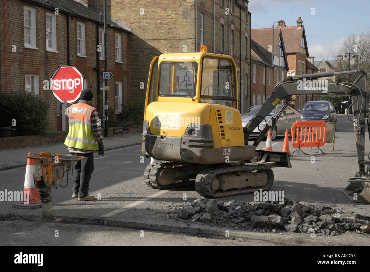 stop go sign and workers at road works Stock Photo - Alamy