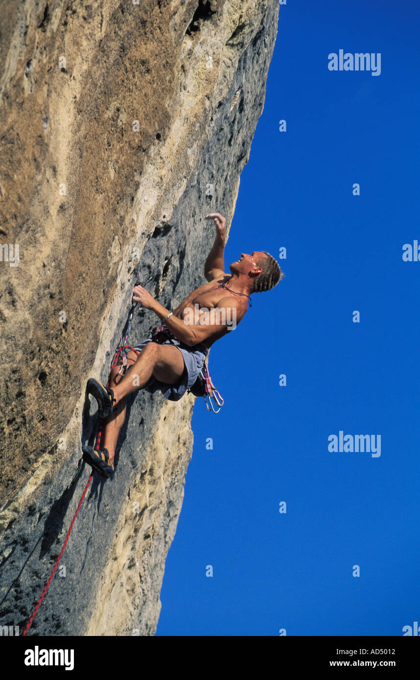 Male rock climber climbing steep rock wall Stock Photo - Alamy