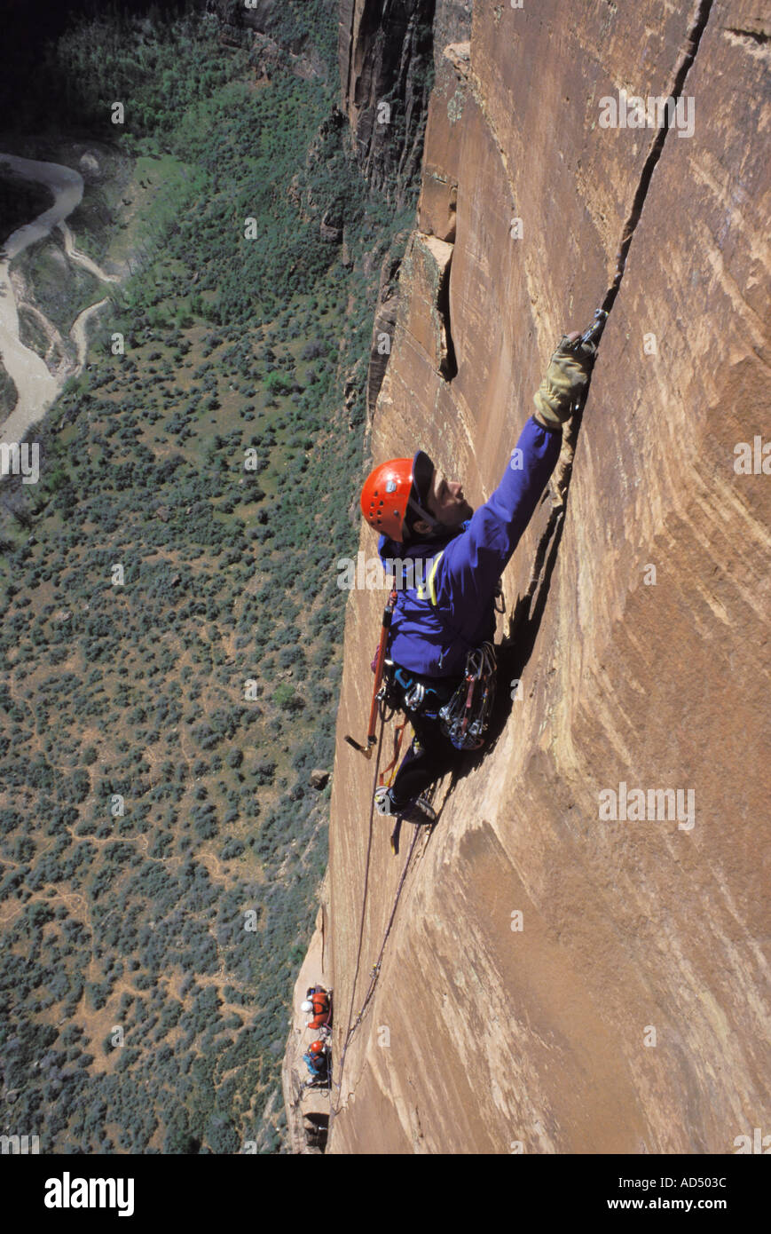 Male rock climber ascending steep cliff Stock Photo - Alamy