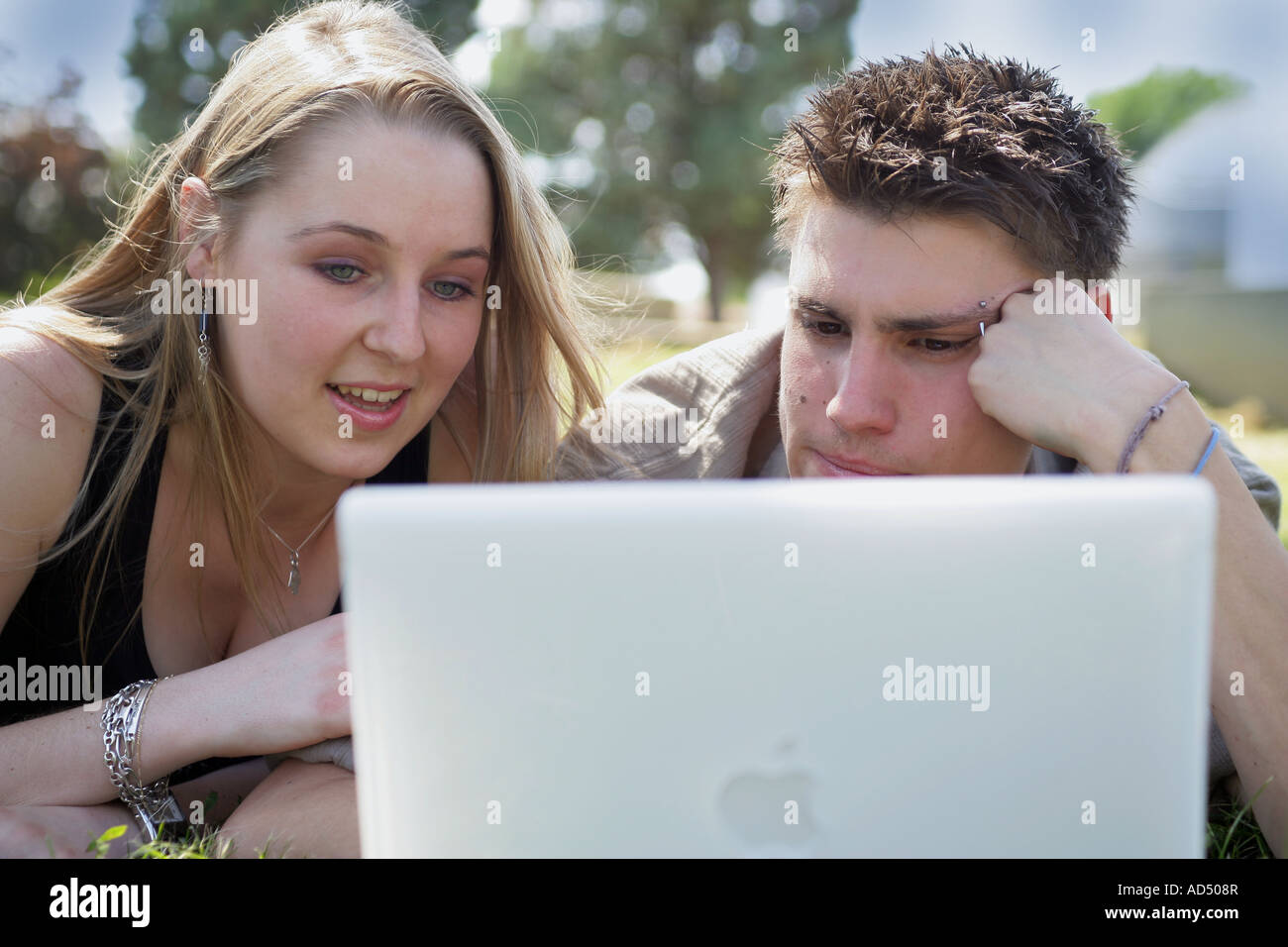 Students laying on the grass and using a laptop Stock Photo - Alamy