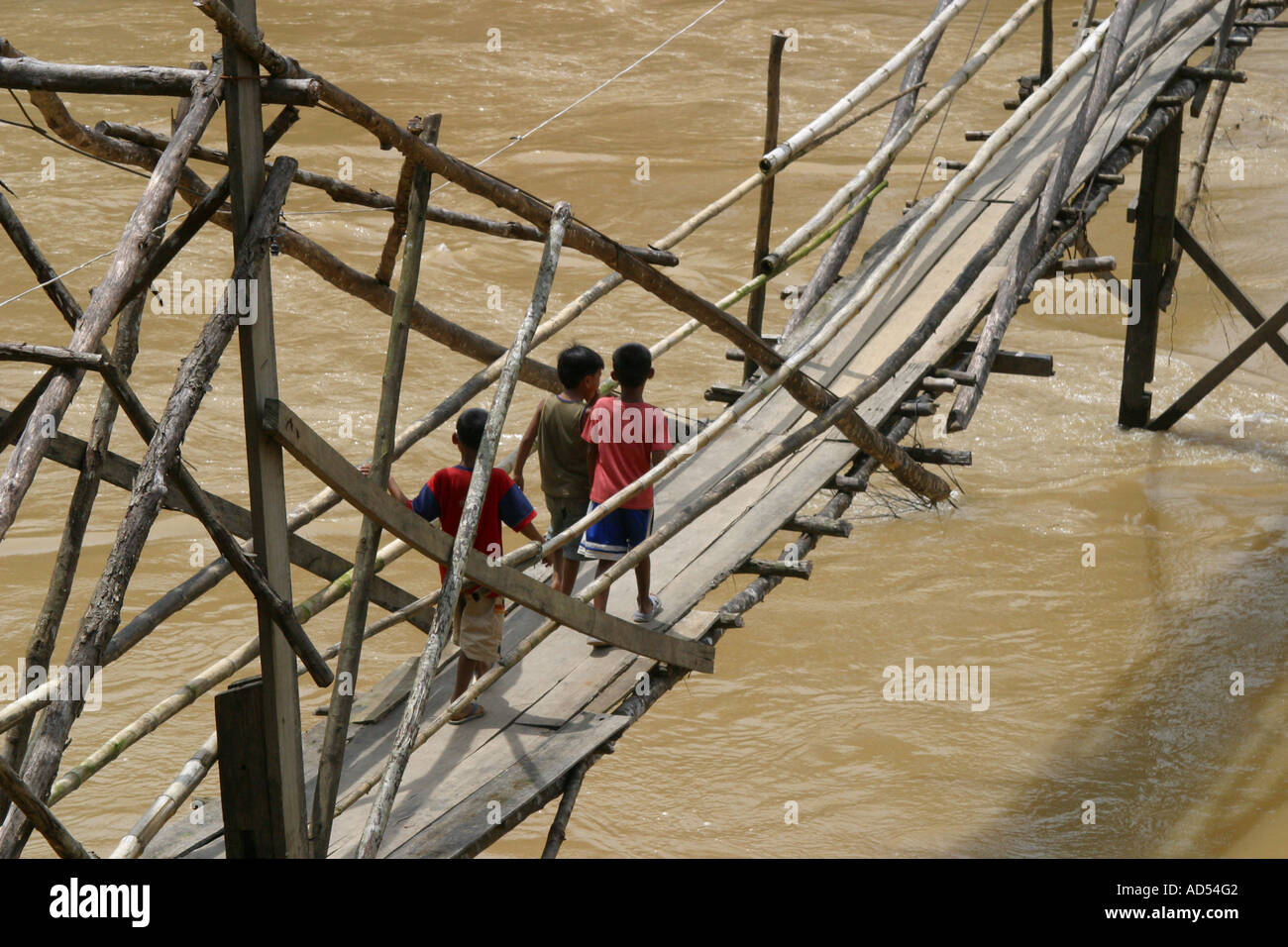Kids crossing a bridge in Vang Vienne Laos Stock Photo - Alamy