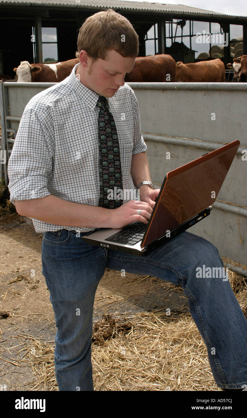 A young Farmer showing practical use of a laptop computer in farming ...