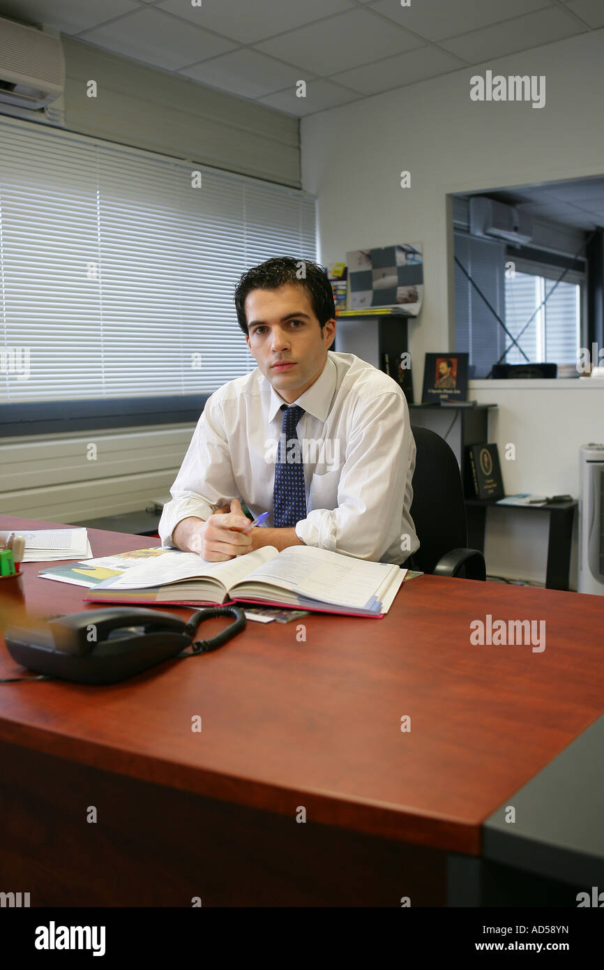 Young professional sitting at his desk Stock Photo - Alamy