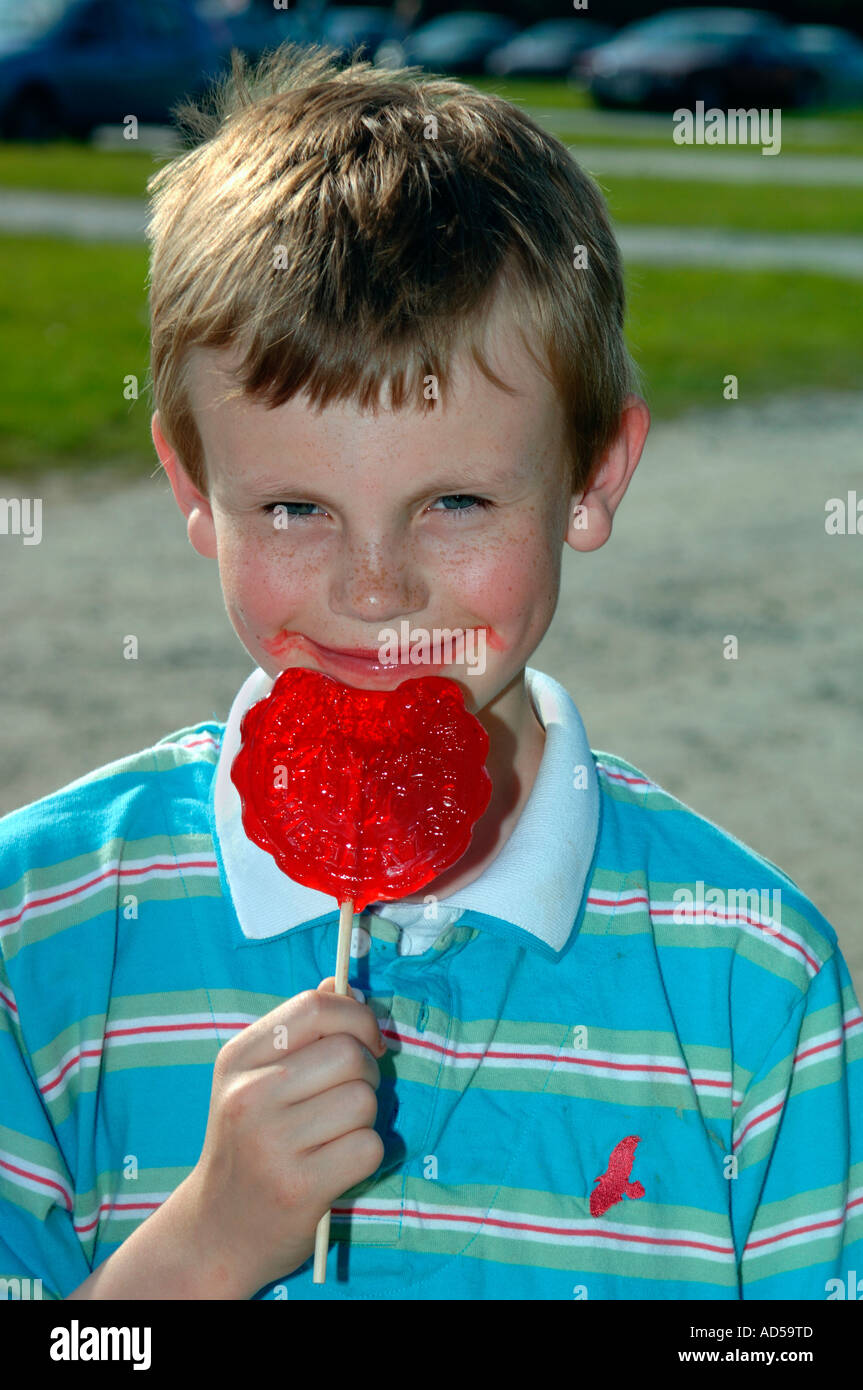 Boy Eating A Red Toffee Lolly Stock Photo - Alamy