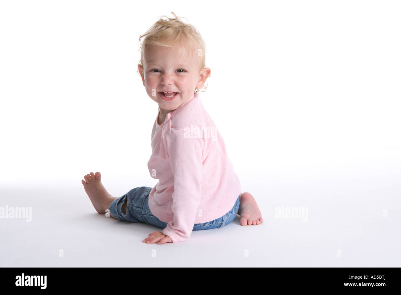 Little girl turning around sitting on the floor Stock Photo - Alamy