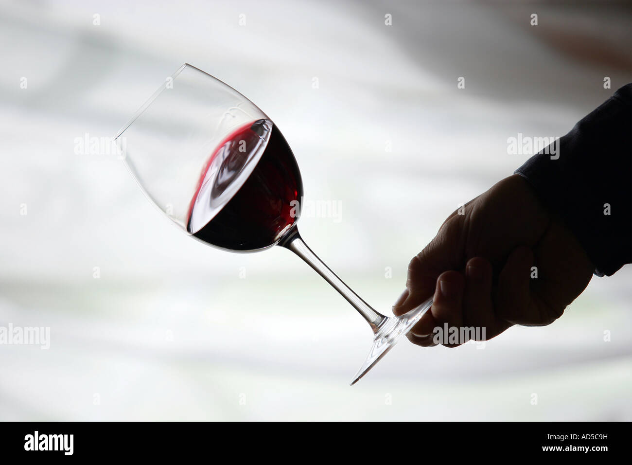 hand holding glass of red wine Stock Photo - Alamy