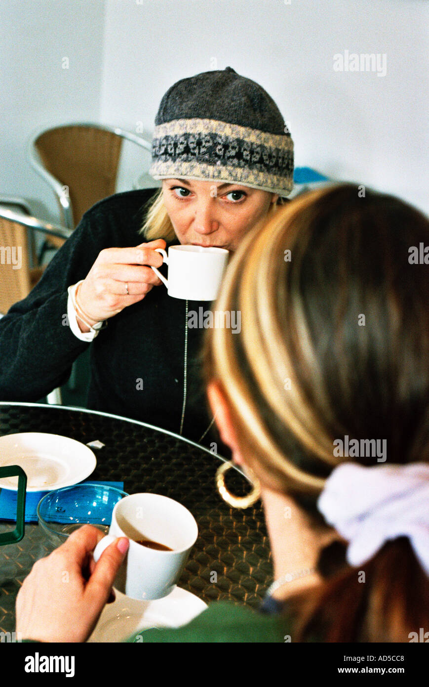 Two friends enjoying a chat and cup of tea in cafe Stock Photo - Alamy