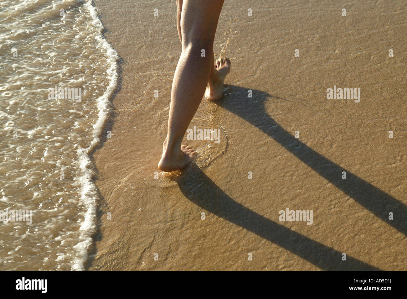 Woman walking on the seashore Stock Photo - Alamy