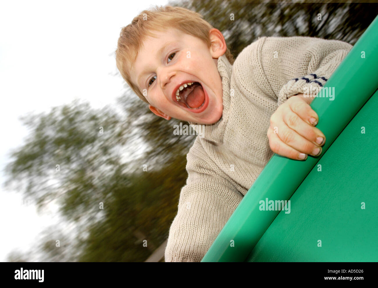 Hyperactive boy on roundabout in play park Stock Photo - Alamy
