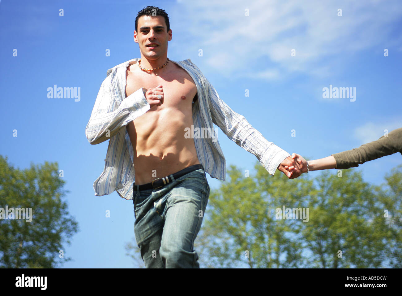 Couple holding hands and running Stock Photo - Alamy