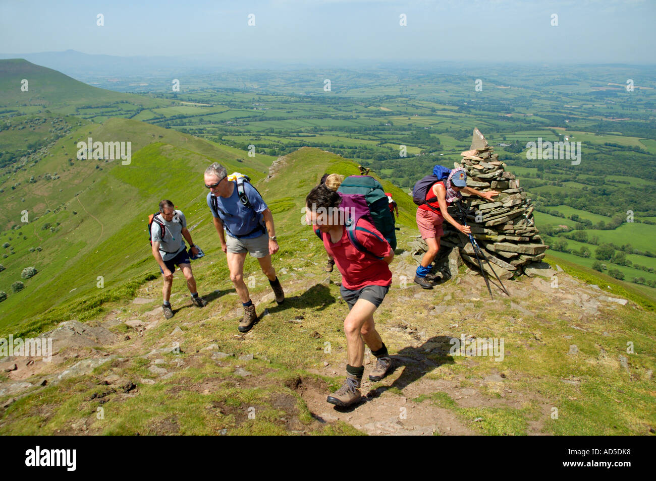 Guided walking group reach the cairn at top of Dragons Back ridge in ...