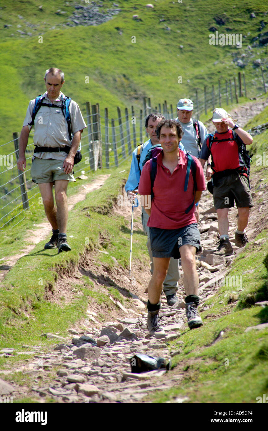 Guided walking group heading down rocky byway at Rhiw Cwnstab in the ...