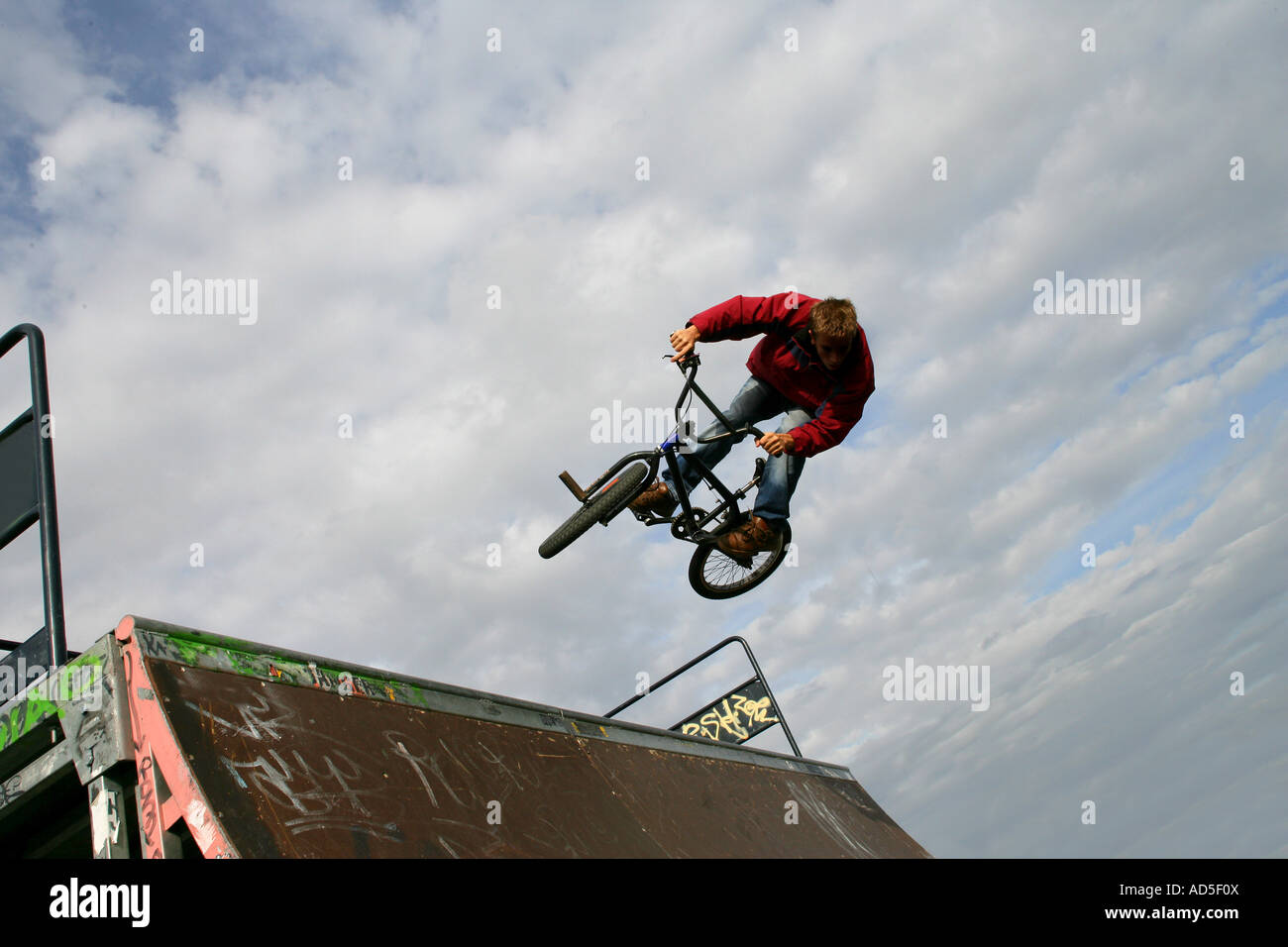 Teenager cycling on a vertical ramp Stock Photo - Alamy
