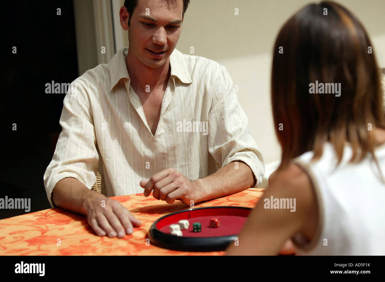 Couple playing dice Stock Photo - Alamy