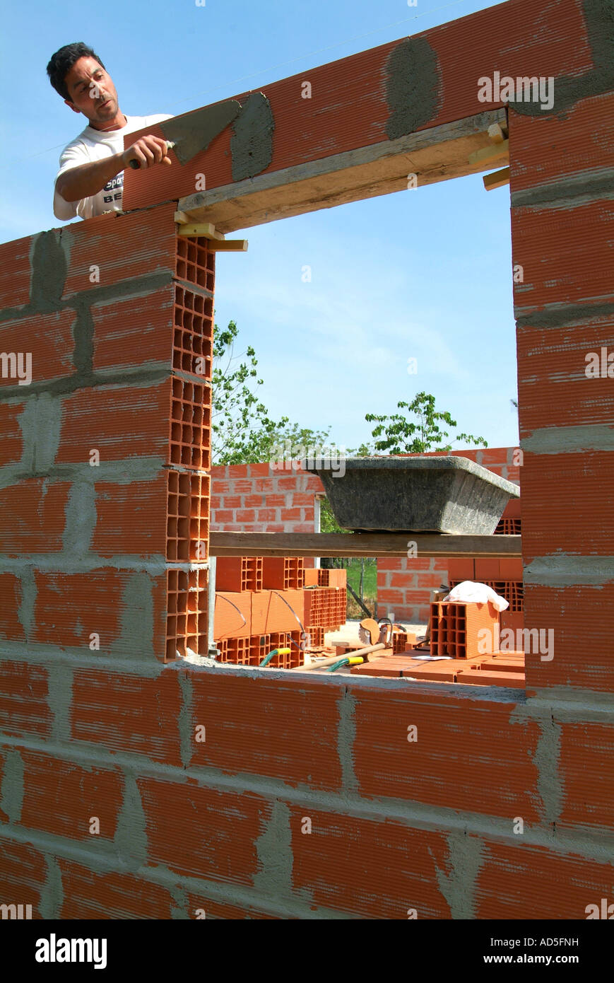 Mason building a brick wall Stock Photo - Alamy