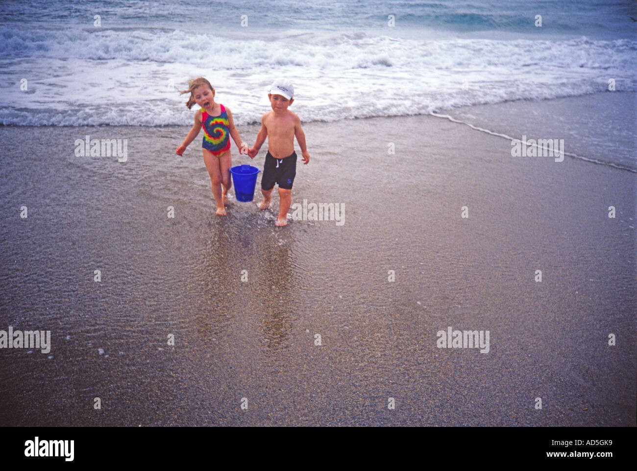 Kids playing at ocean Stock Photo - Alamy