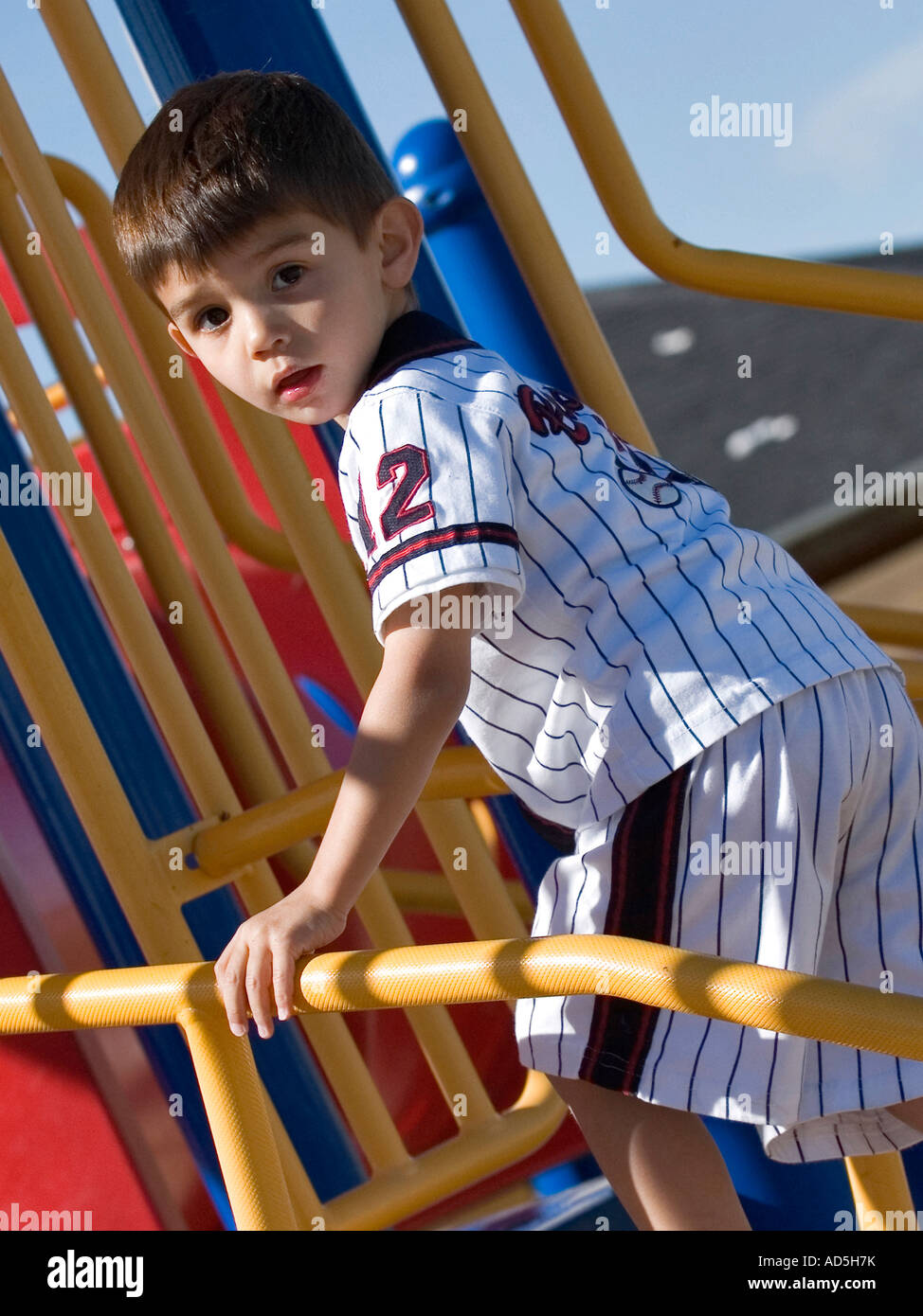 Boy playing on playground equipment looks at camera Stock Photo - Alamy