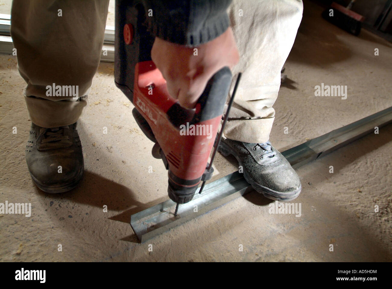 Worker using an electric drill Stock Photo - Alamy