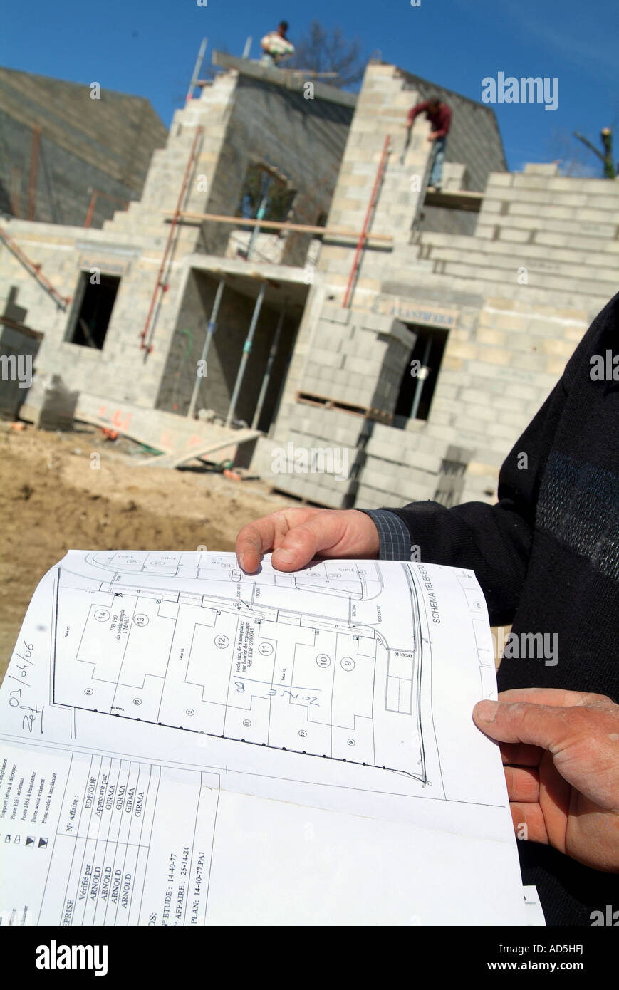 Worker looking at the plan of the building Stock Photo - Alamy
